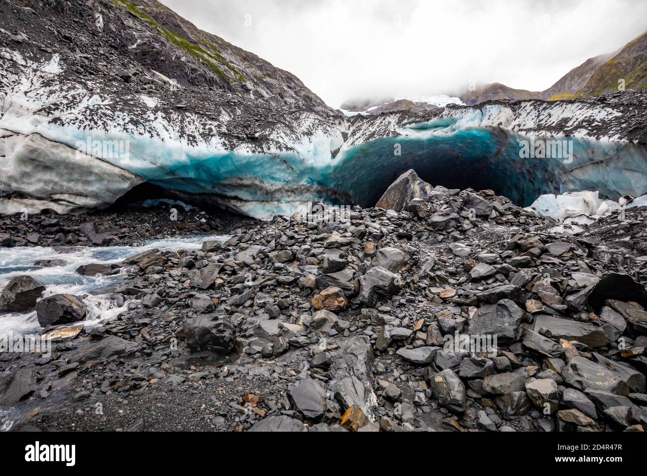 Scenic glacier ice caves with river flowing out from inside nobody ...