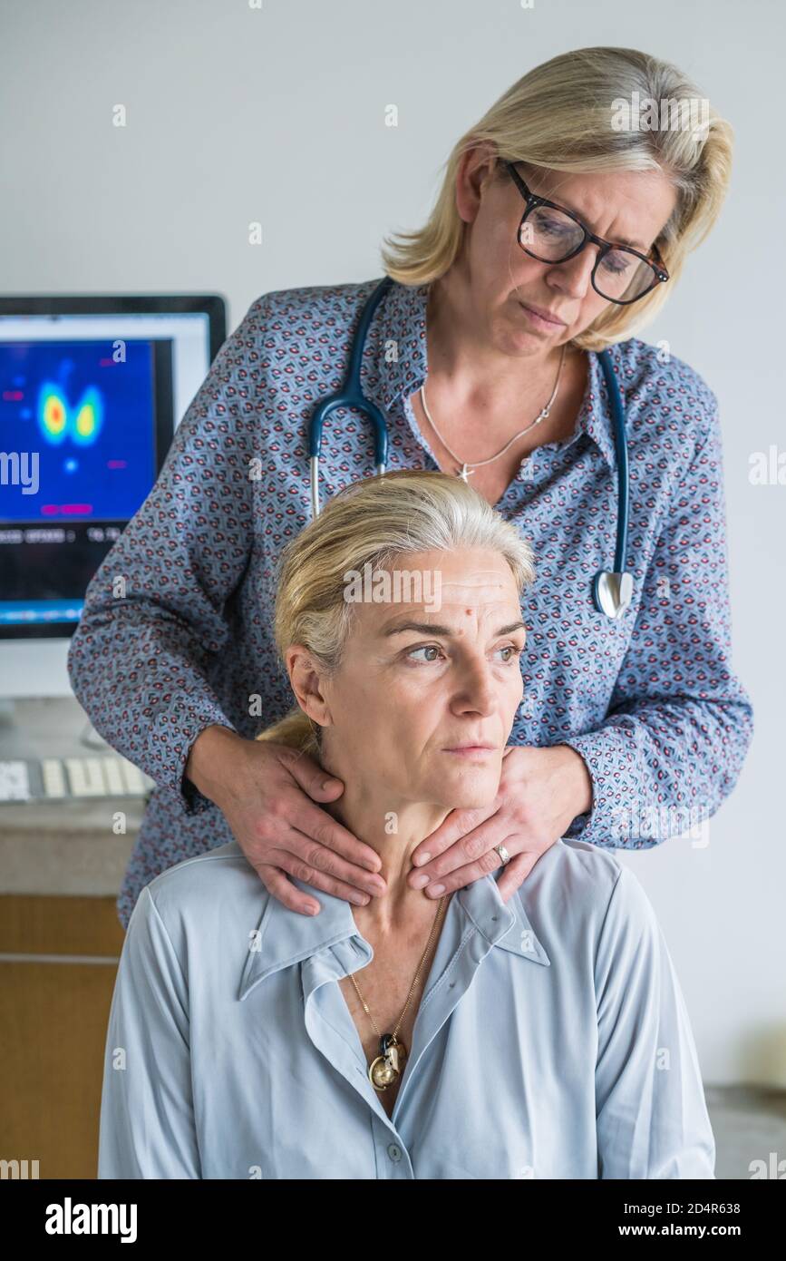Doctor examining the thyroid gland of a patient Stock Photo - Alamy
