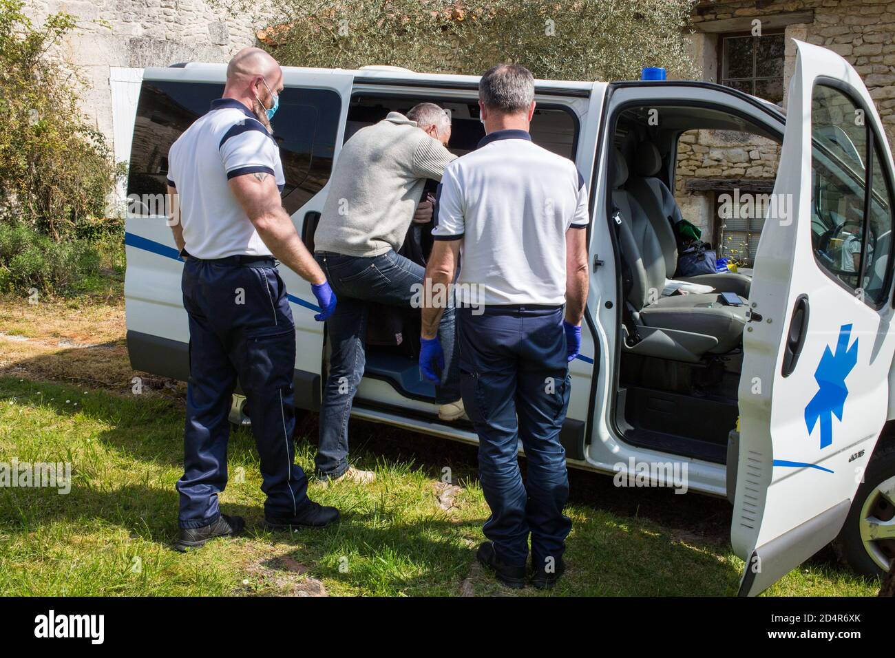 Ambulance drivers in front of the home of a patient with suspected ...