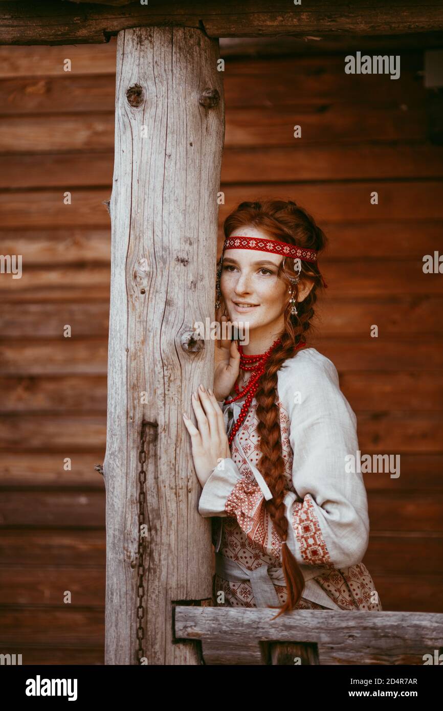 A beautiful Slavic girl with long blonde hair and brown eyes in a white ...