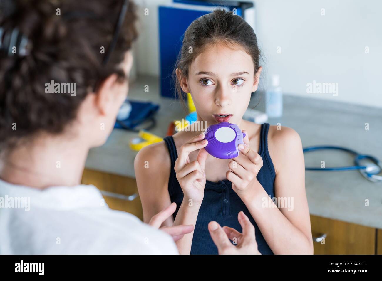 Doctor instructing a girl on how to use an asthma inhaler Stock Photo ...