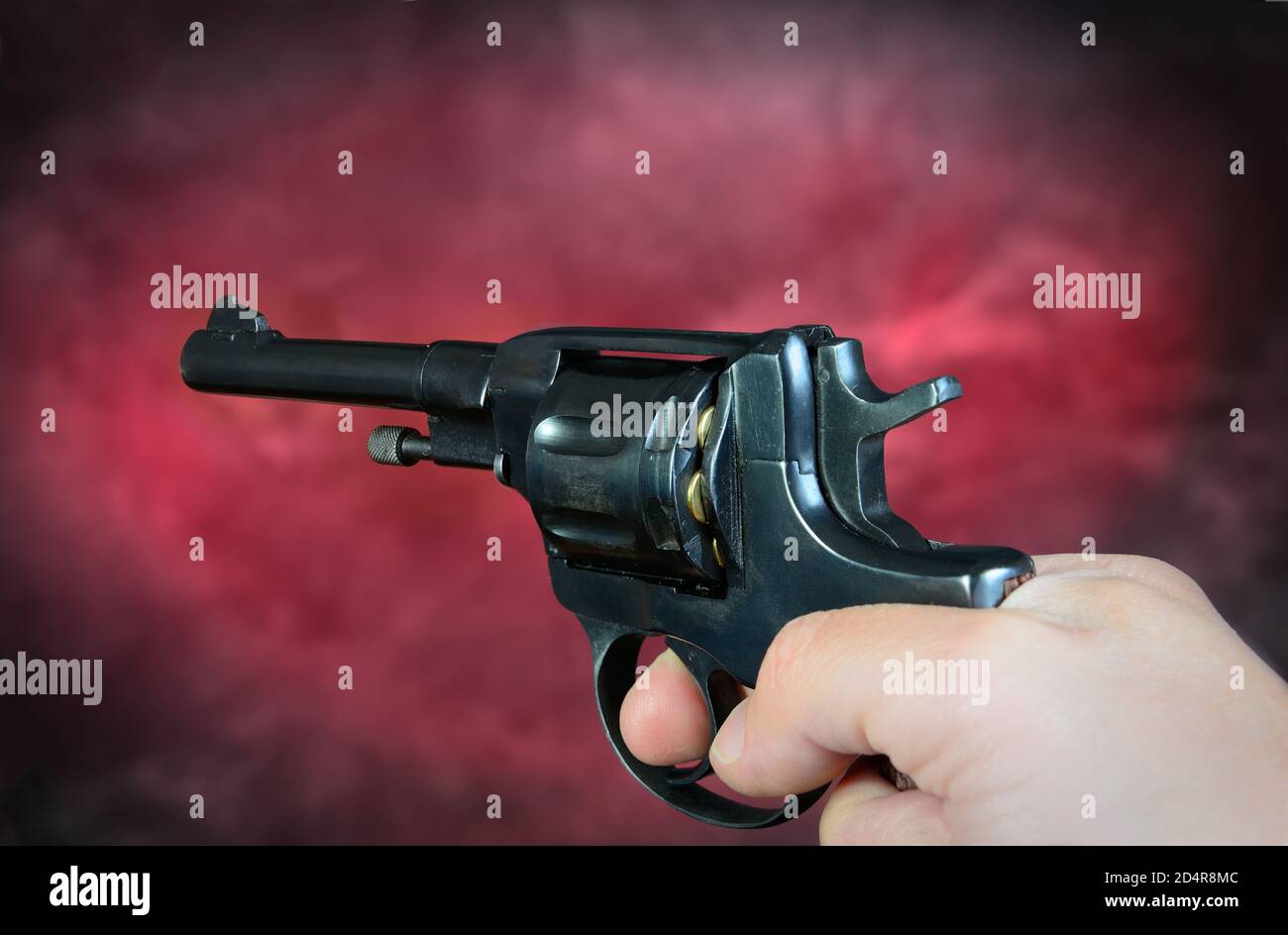 Hand with revolver gun on red background Stock Photo - Alamy