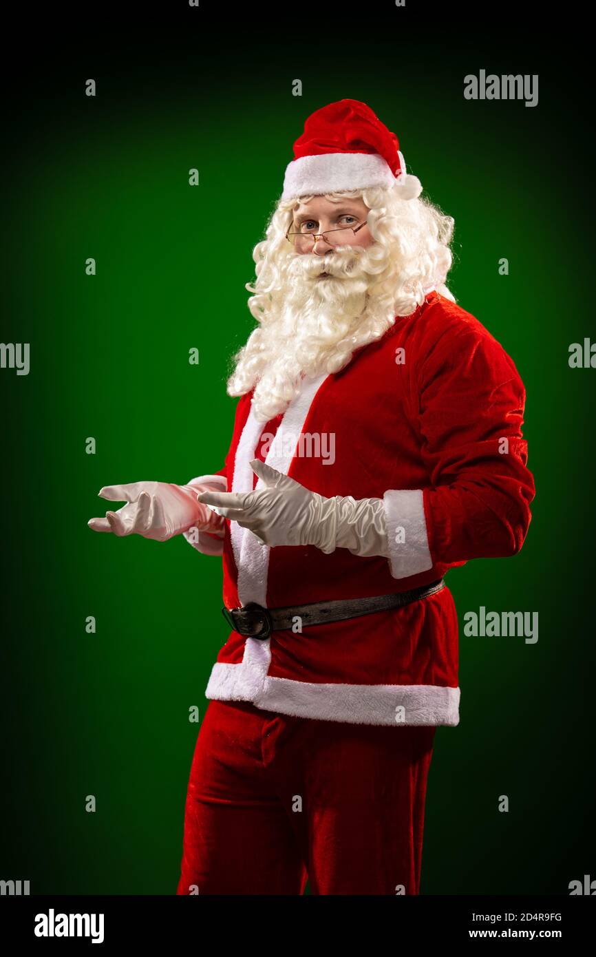 Male actor in a costume of Santa Claus dancing and gesturing, posing on ...