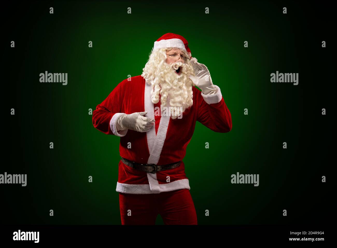 Male actor in a costume of Santa Claus dancing and gesturing, posing on ...