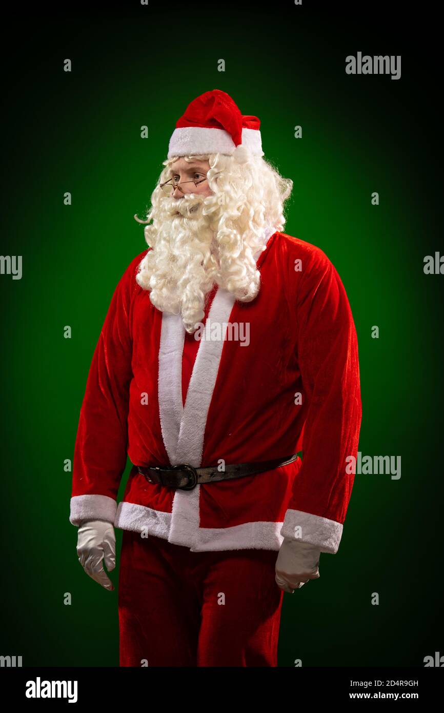 Male actor in a costume of Santa Claus dancing and gesturing, posing on ...