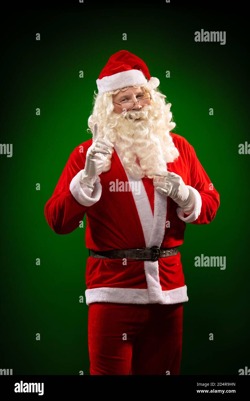 Male actor in a costume of Santa Claus dancing and gesturing, posing on ...