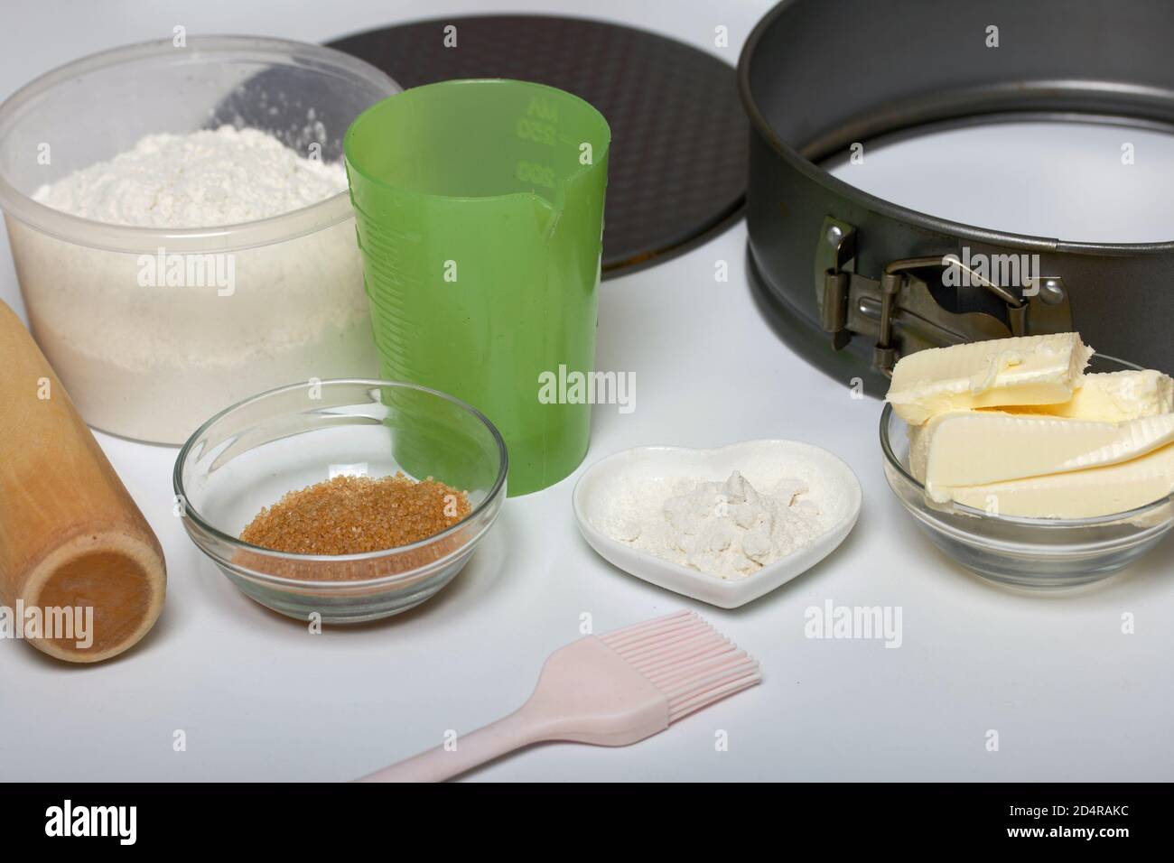 Butter on a kitchen scale. Sugar and flour in containers, collapsible ...