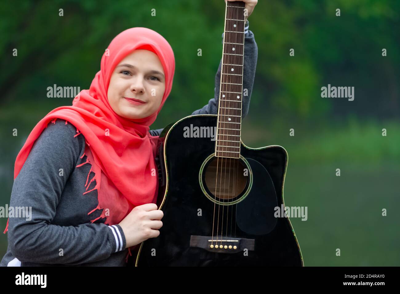 Portrait of blue eyed muslim girl holding guitar Stock Photo - Alamy
