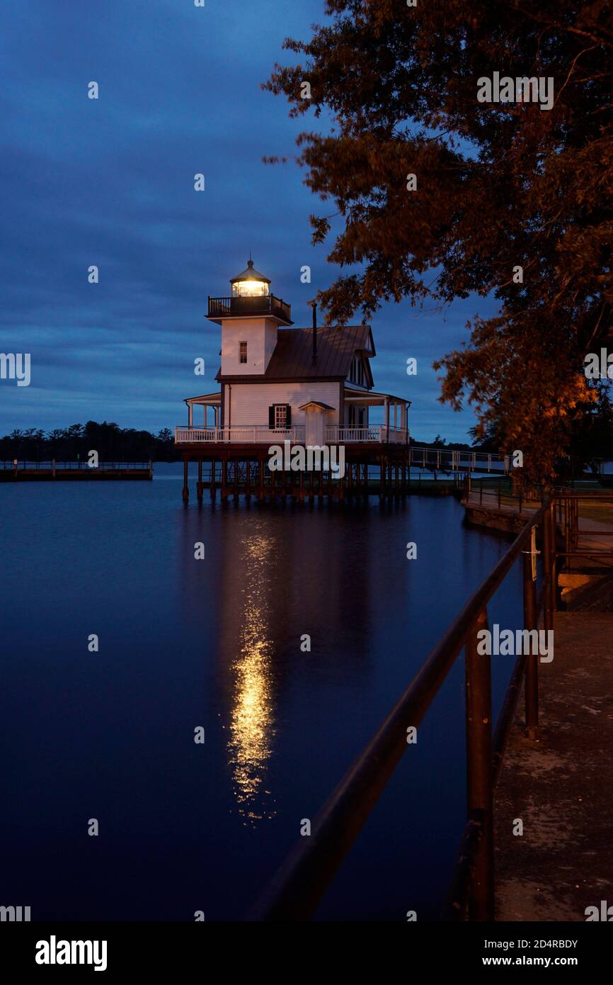 Roanoke River lighthouse reflecting in the water at dusk Stock Photo ...