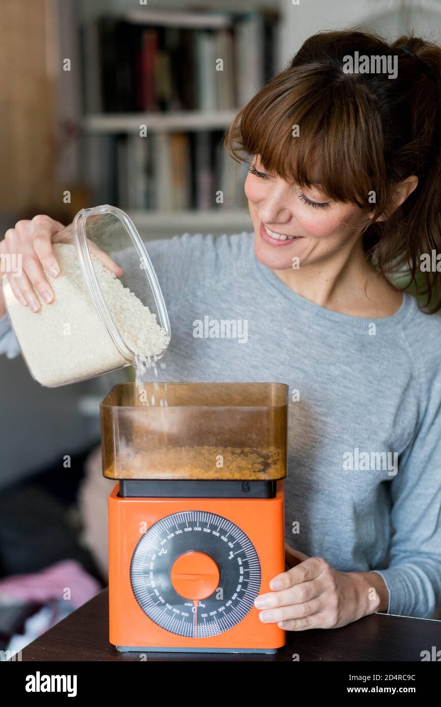 Woman weighing rice Stock Photo - Alamy