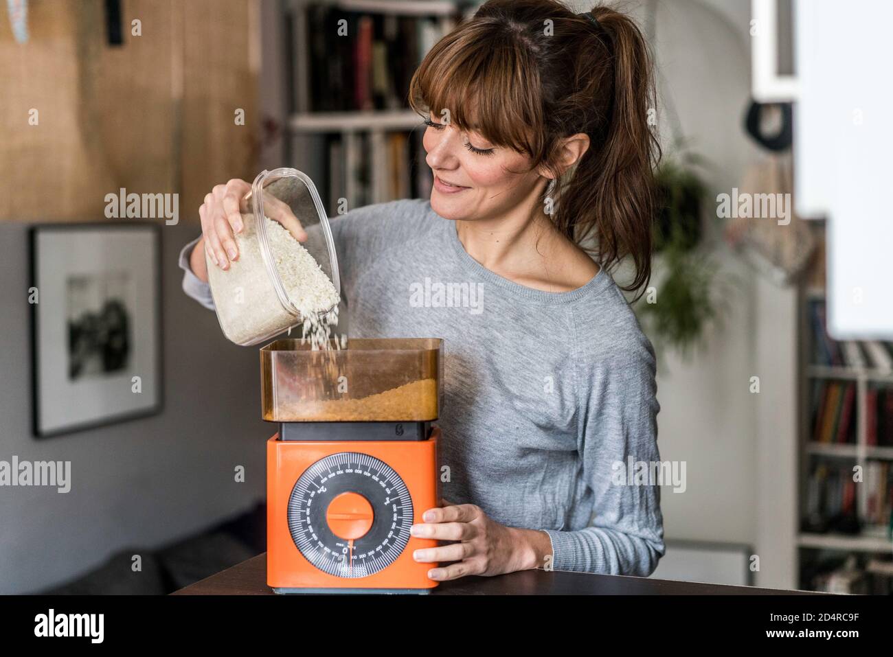 Woman weighing rice Stock Photo - Alamy