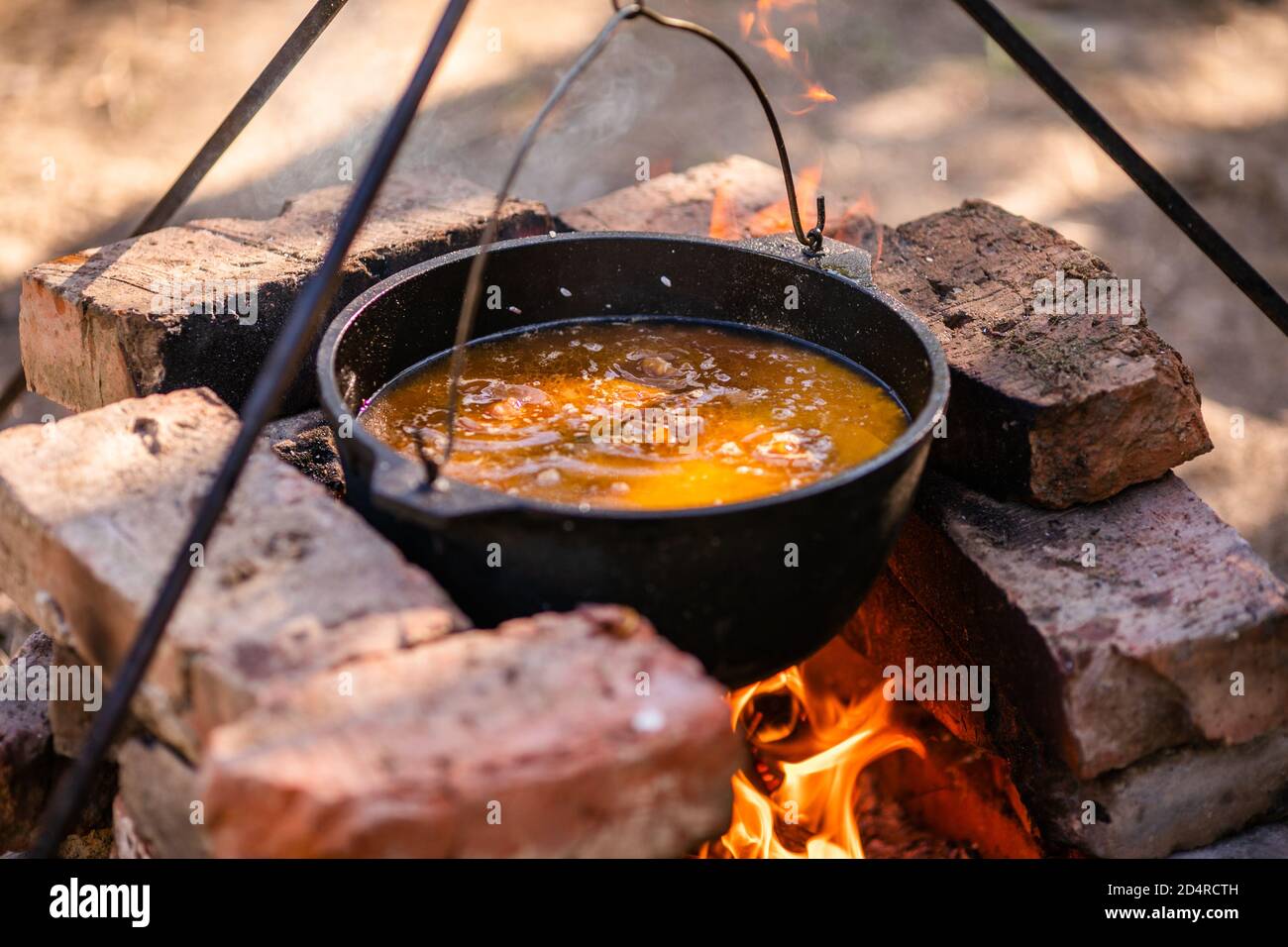 Preparation of raditional armenian pilaf in a cauldron on an open fire ...
