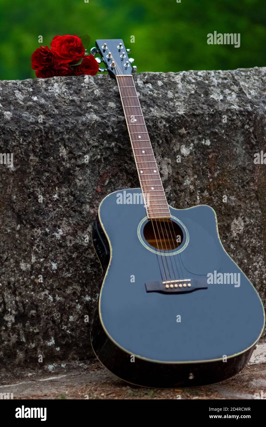 Acoustic guitar and bouquet of red roses Stock Photo - Alamy