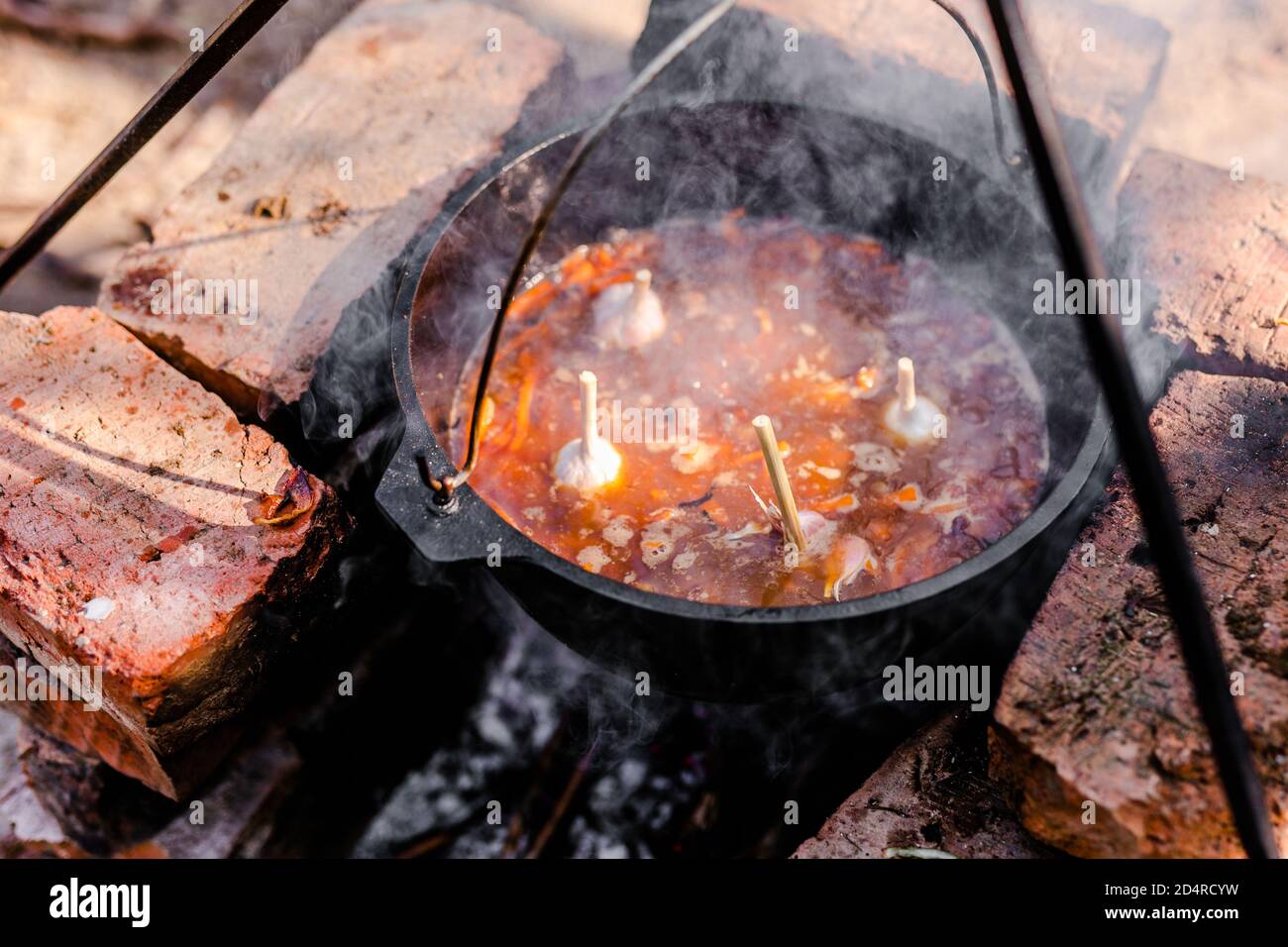 Preparation of raditional armenian pilaf in a cauldron on an open fire ...