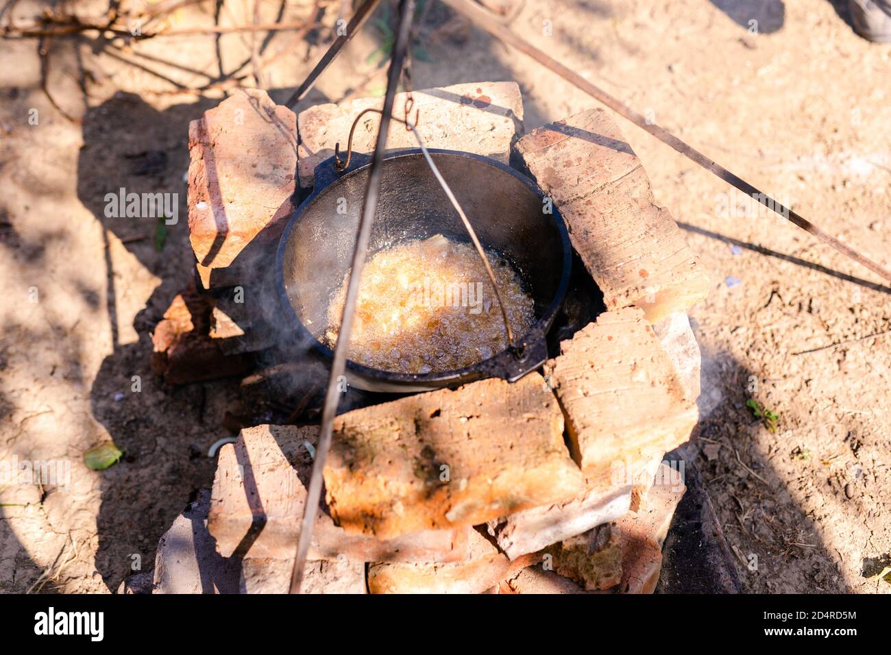 Preparation of raditional armenian pilaf in a cauldron on an open fire ...