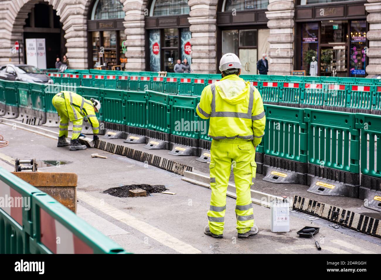 Construction worker building bicycle lane in Regent street, London ...