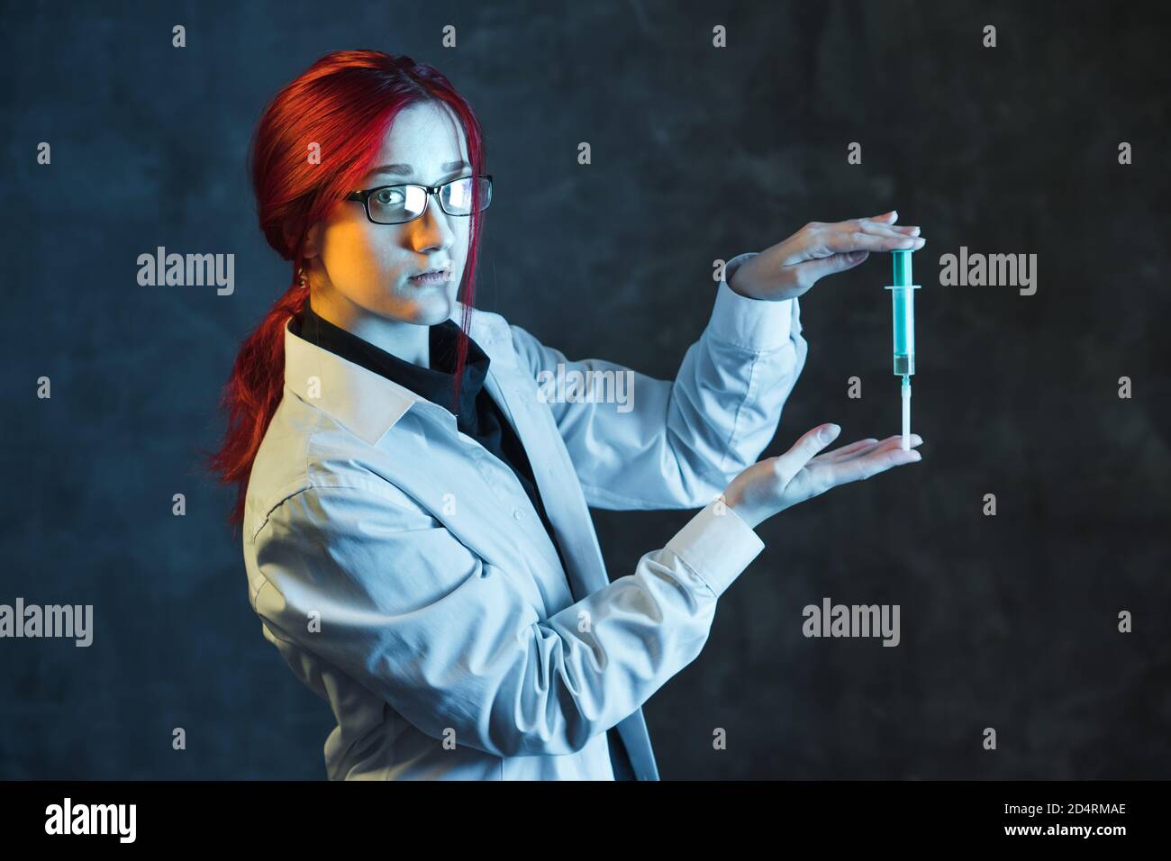 Doctor shows syringe with vaccine to fight coronavirus. Nurse on dark ...