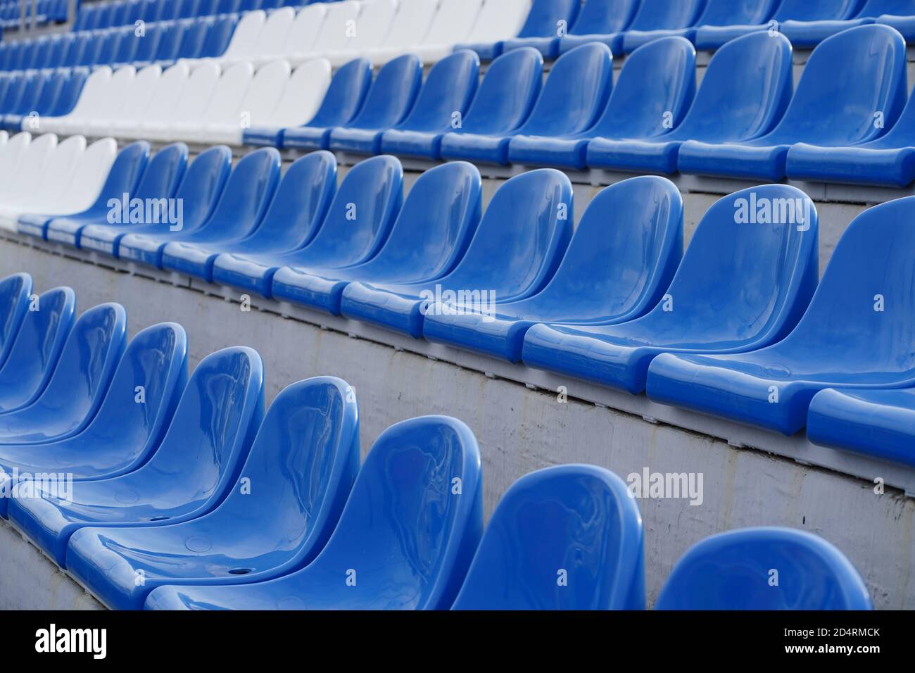 Bleachers in a sports stadium. White and blue seats in a large street ...