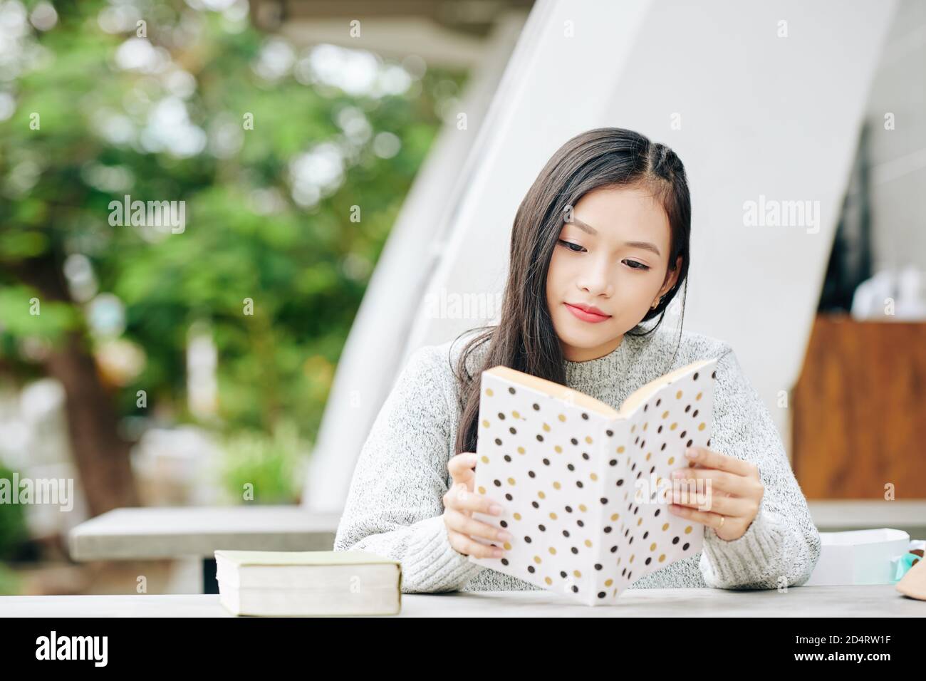 Teenage girl enjoying reading Stock Photo - Alamy