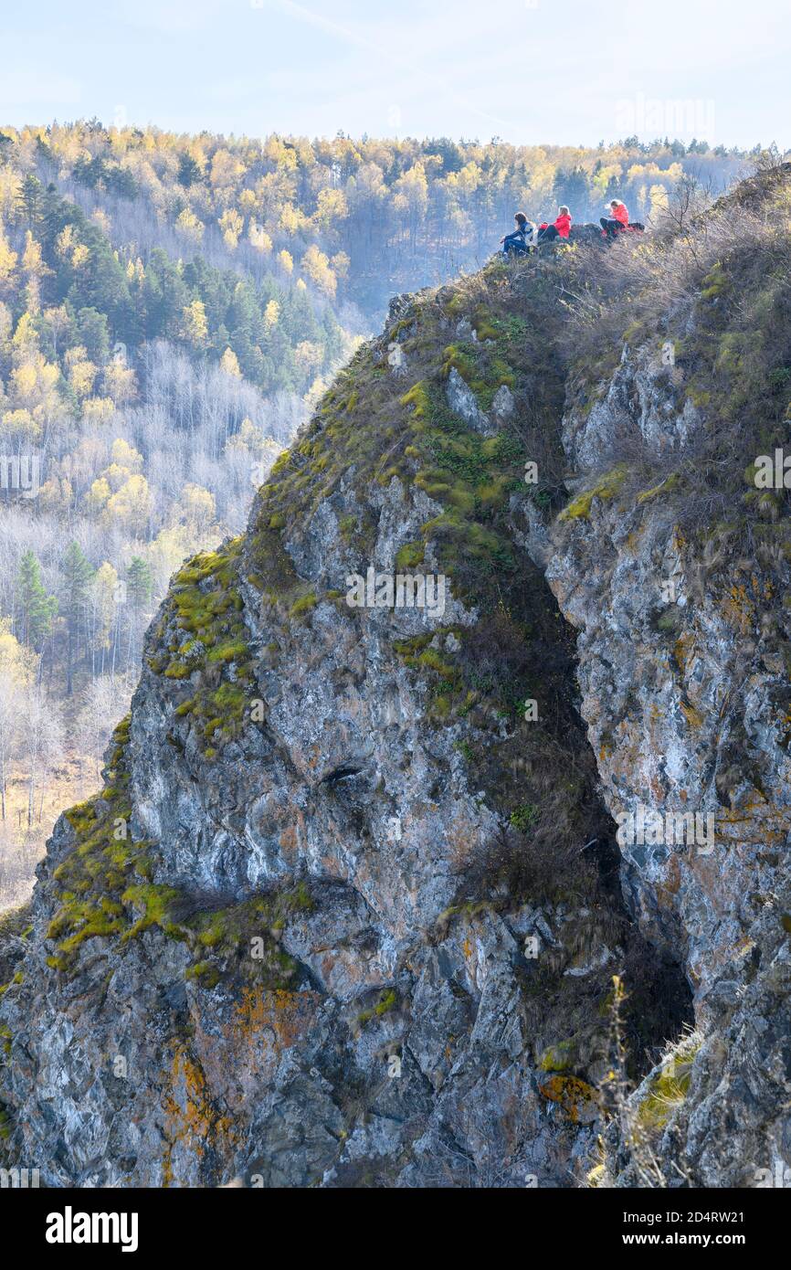 Family with a child on top of a mountain cliff in the Siberian taiga in ...