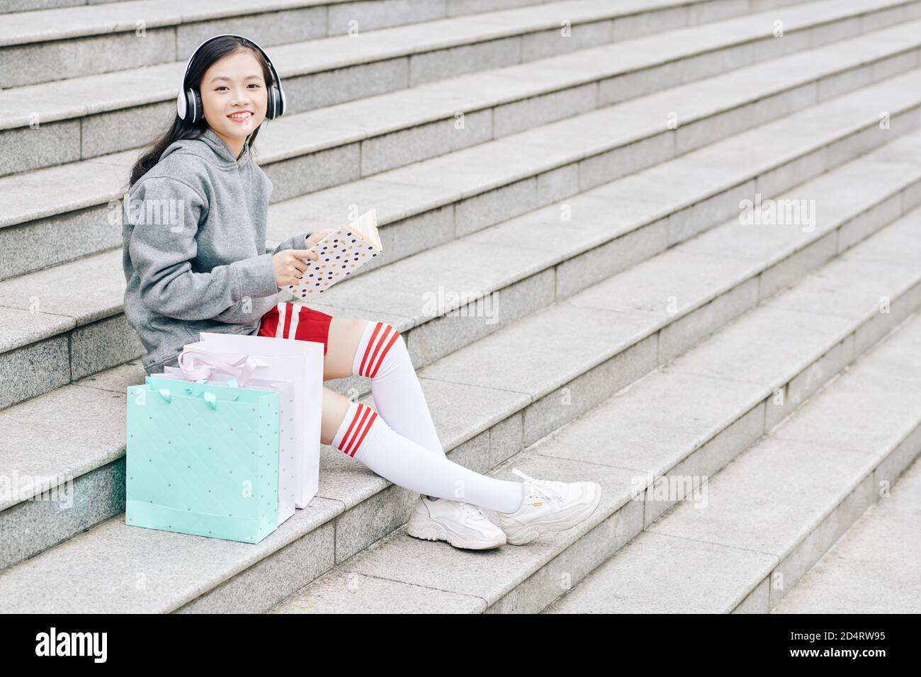 Teenage girl sitting on steps Stock Photo - Alamy