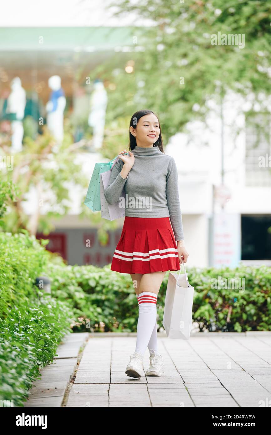 Girl walking outdoors with paper-bags Stock Photo - Alamy