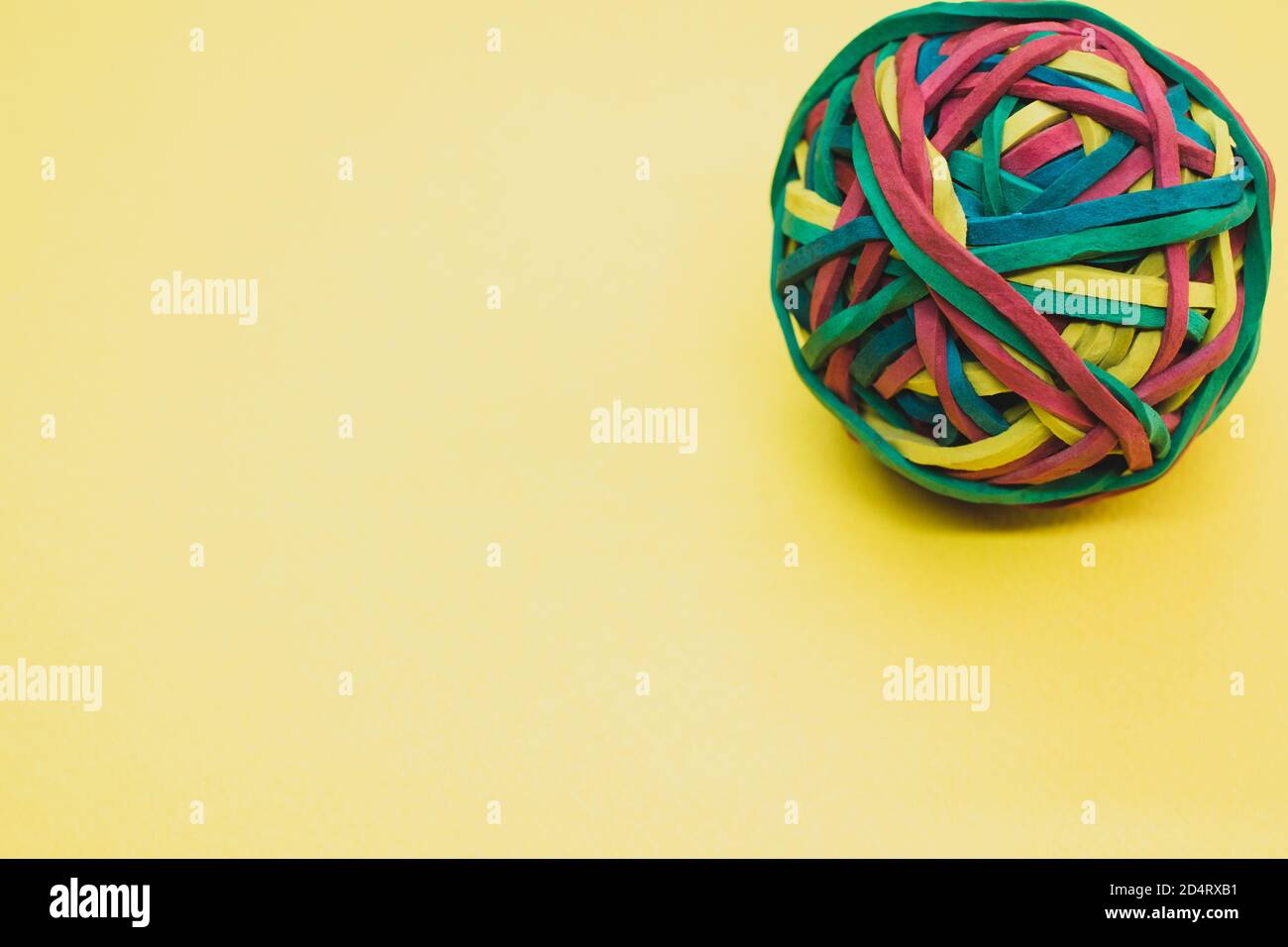 Top view of a rubber ball made out of rubber bands isolated on a yellow ...