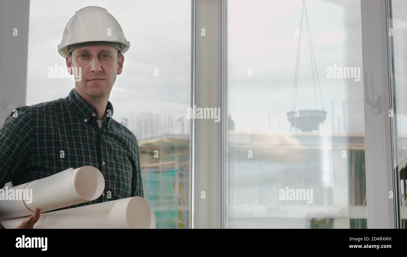 Engineer or architect holding blueprint and looking at the camera Stock ...