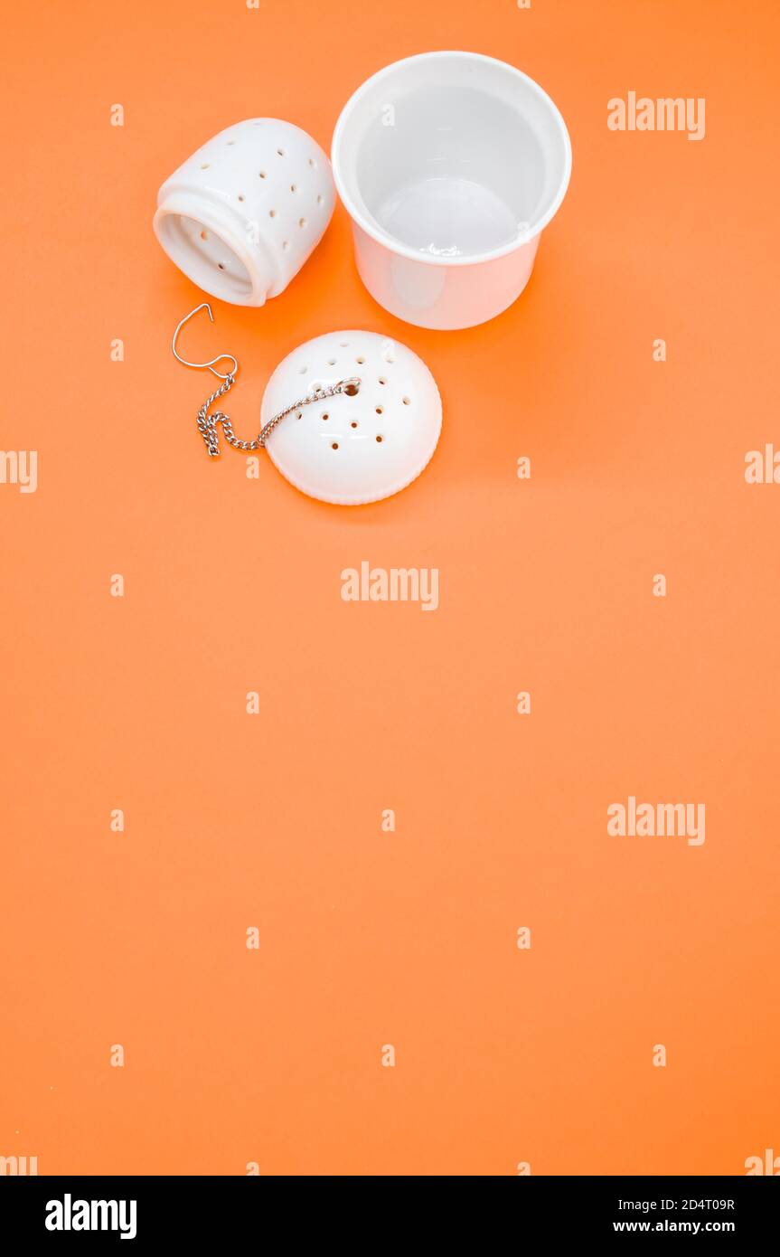 Vertical shot of a white tea strainer and an infuser isolated on an ...