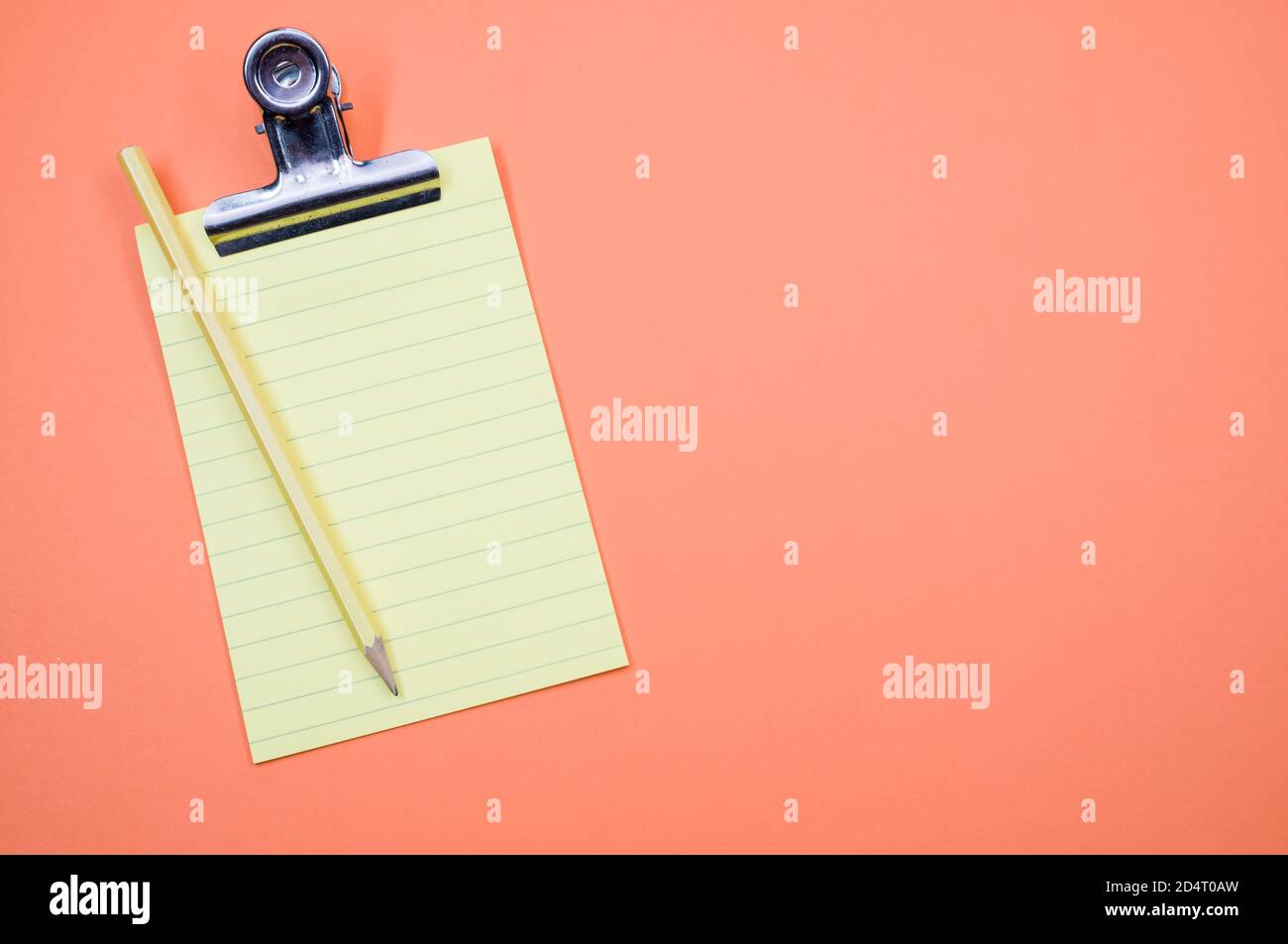 Top view of a notepad with a paper clipper and a pencil isolated on an ...