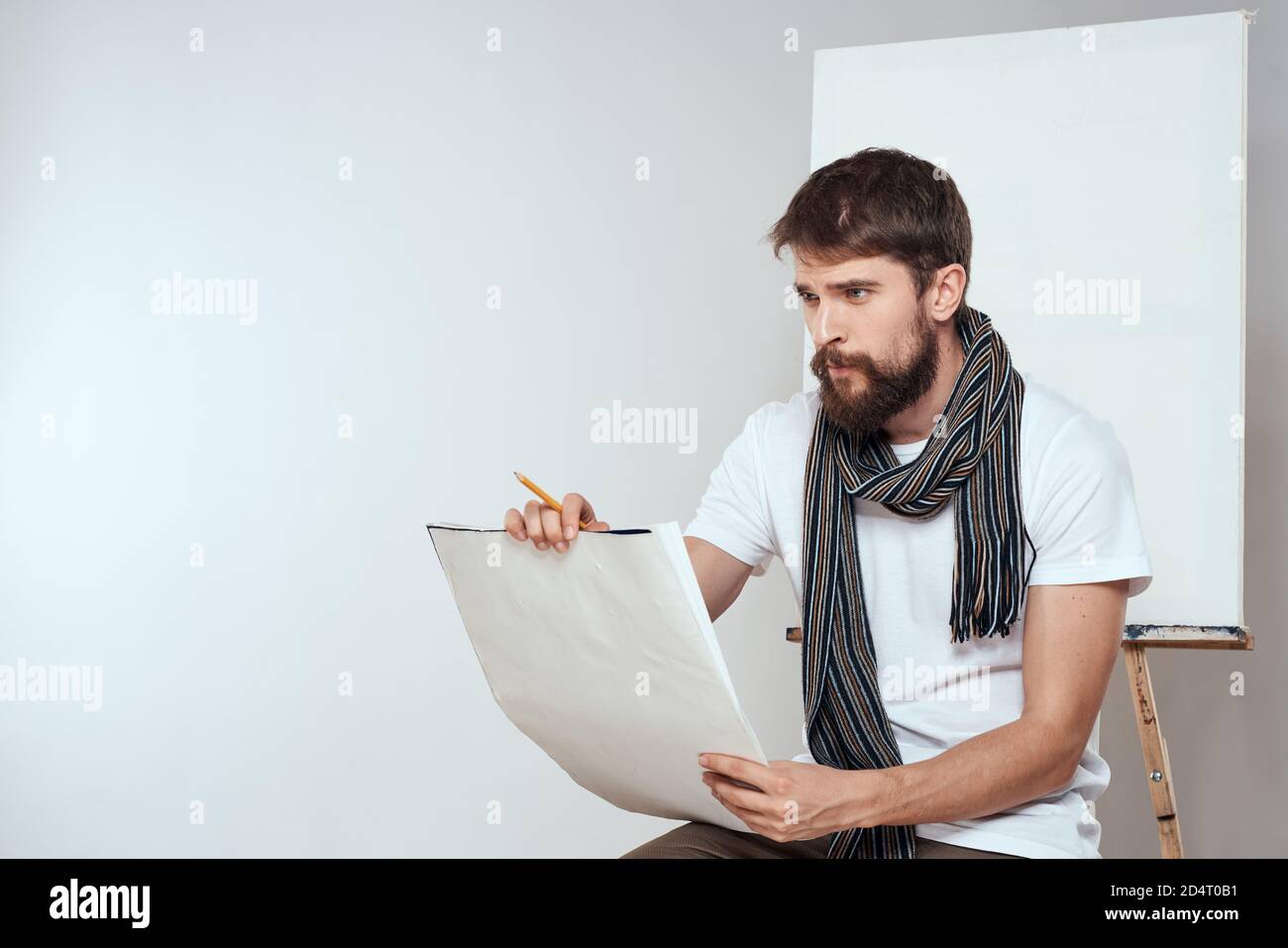 Male artist sitting on chair drawing brush easel hobby Creative light ...