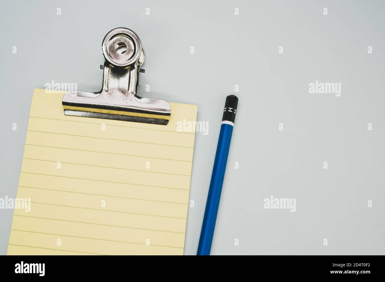 Top view of a notepad with a paper clipper and a pencil isolated on a ...