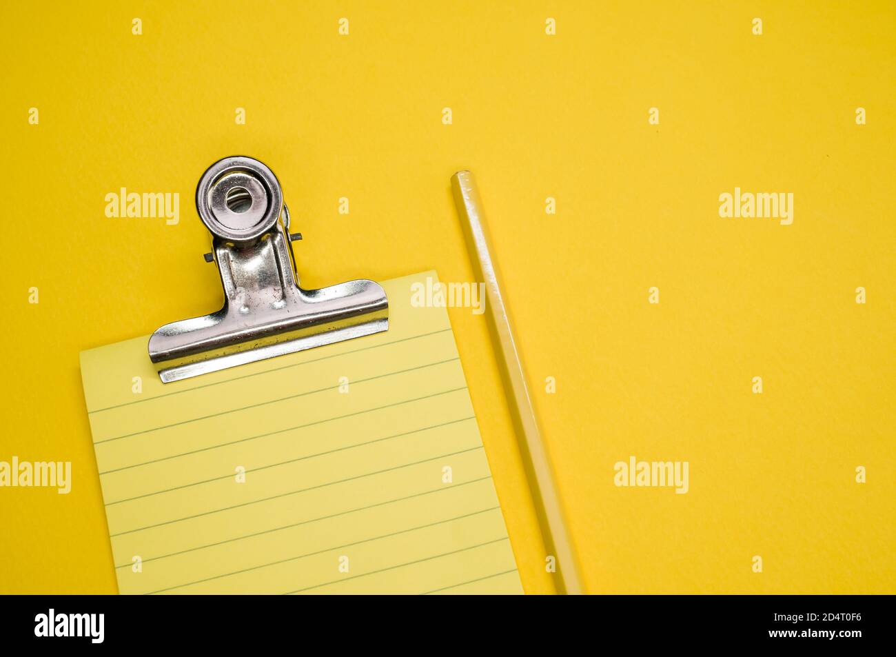 Top view of a notepad with a pencil and a paper clipper isolated on a ...