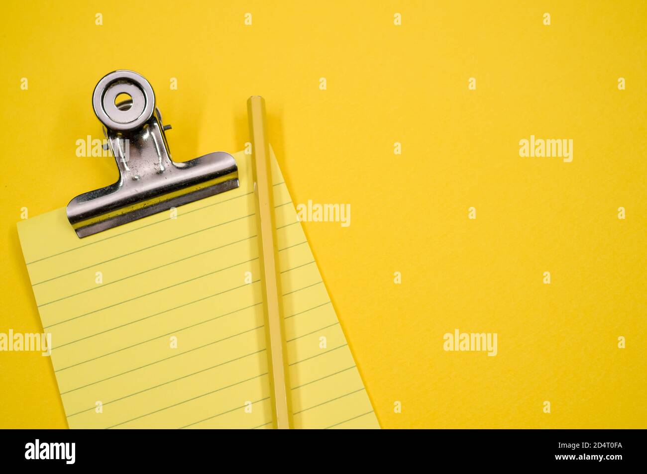 Top view of a notepad with a paper clipper and a pencil isolated on a ...