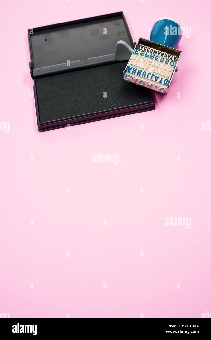 Vertical shot of a rubber stamp roller with words on it with ink ...