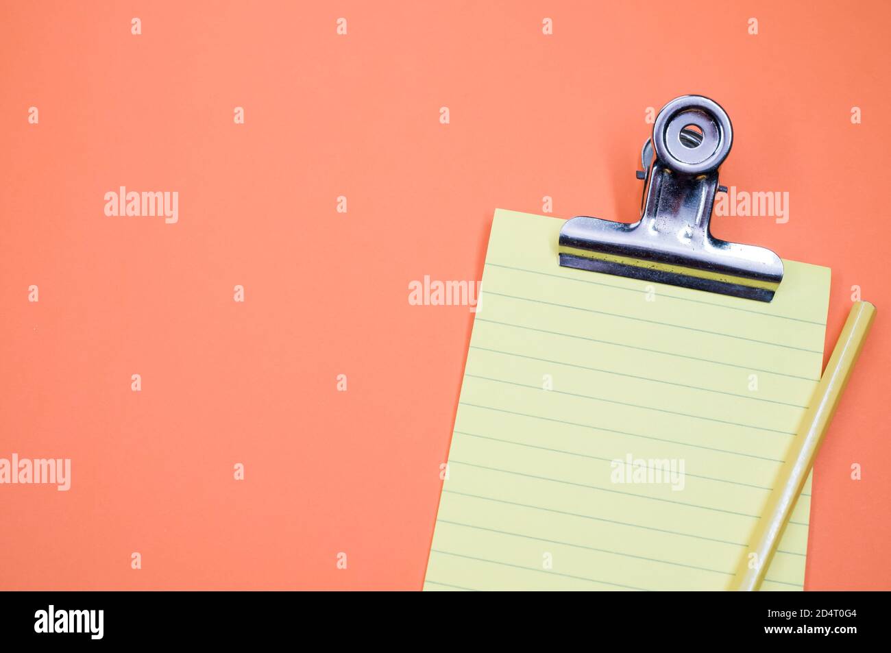Top view of a notepad with a paper clipper and a pencil isolated on an ...