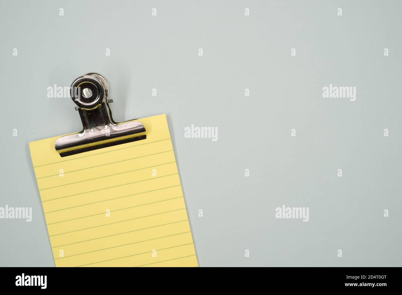 Top view of a notepad with a paper clipper isolated on a gray ...