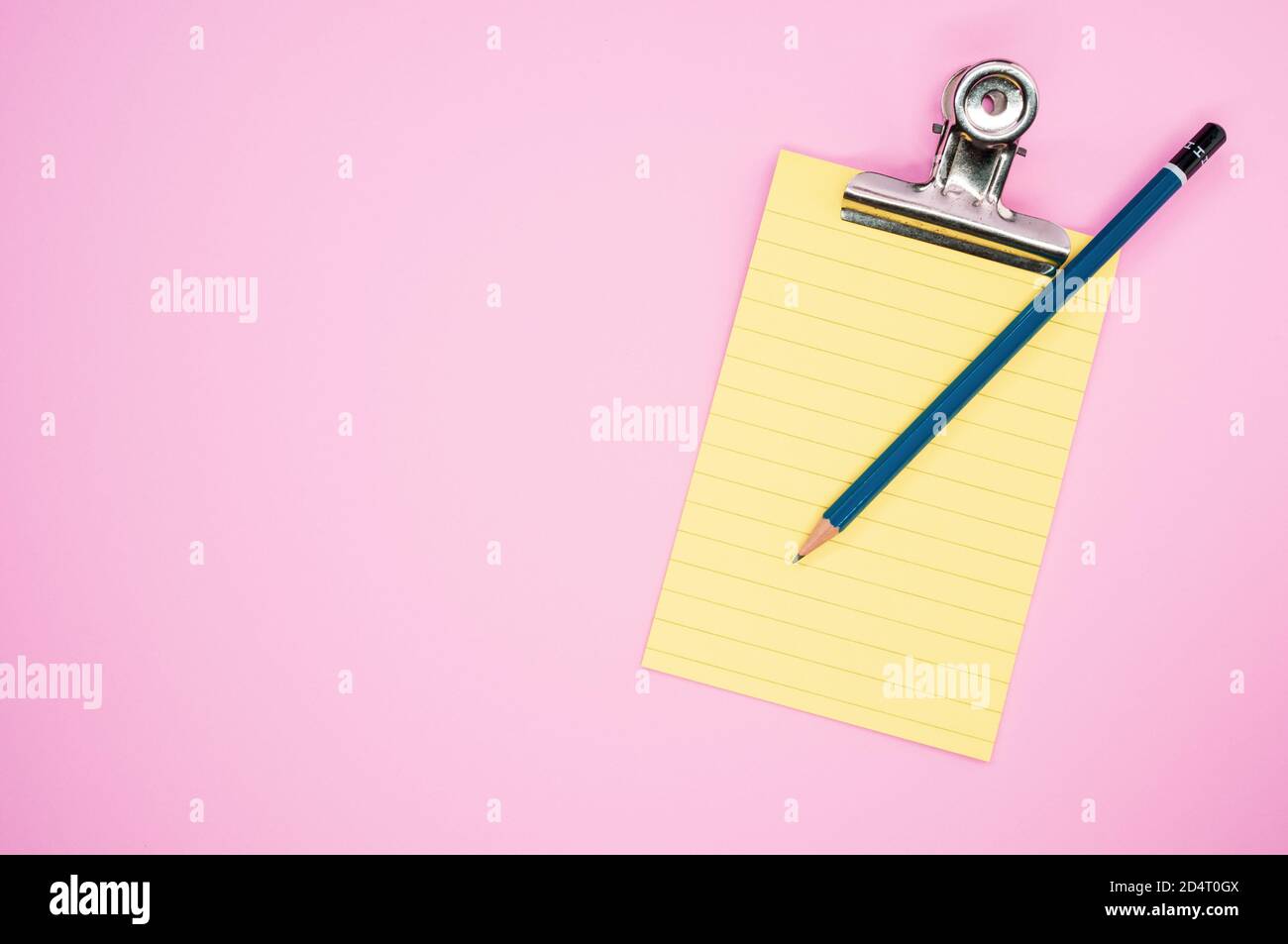 Top view of a notepad with a paper clipper and a pencil isolated on a ...