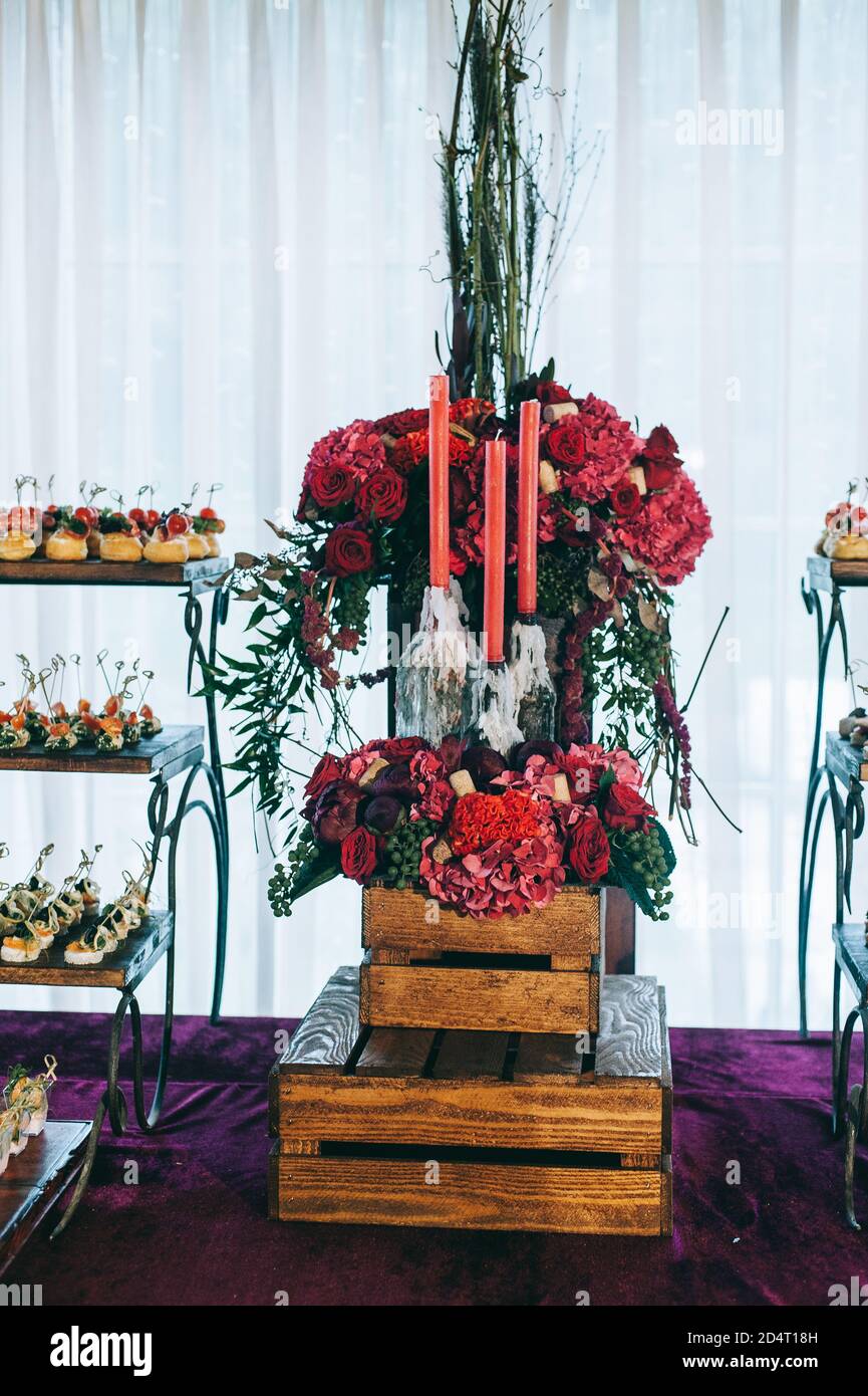 Flower arrangement with candles in the color of marsala made of red ...