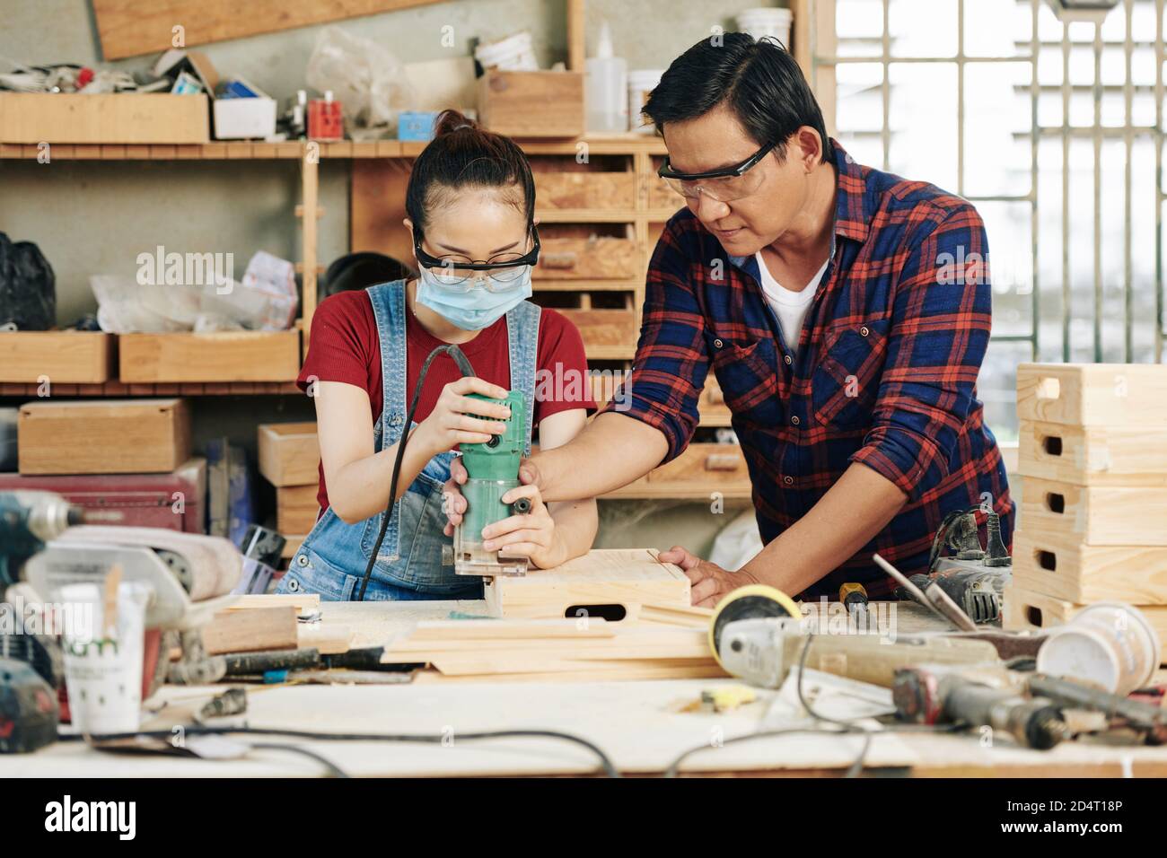 Experienced carpenter helping apprentice Stock Photo - Alamy