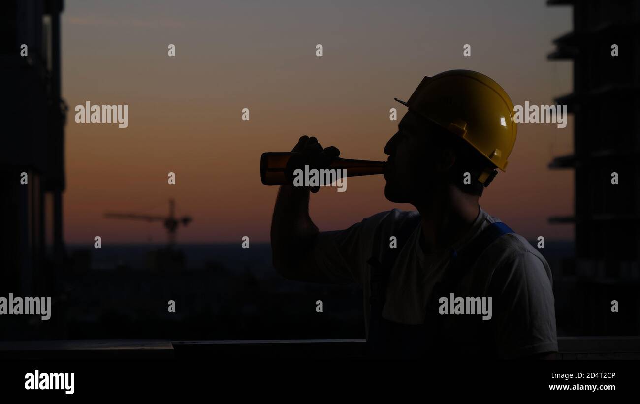 Construction worker drinking beer in helmet Stock Photo - Alamy