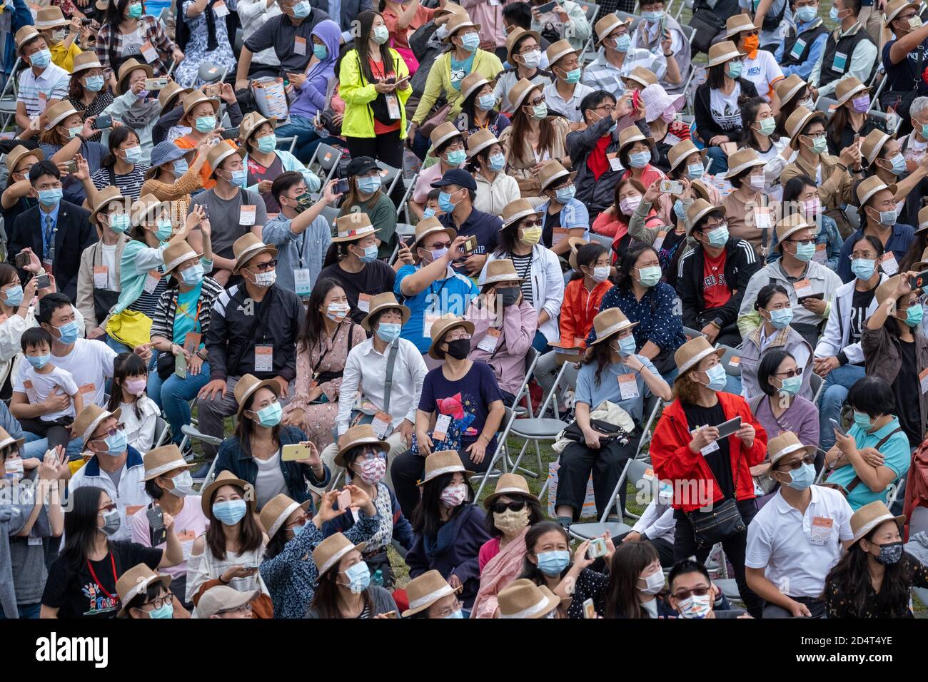A large crowd of people wearing face masks are seen watching the show ...
