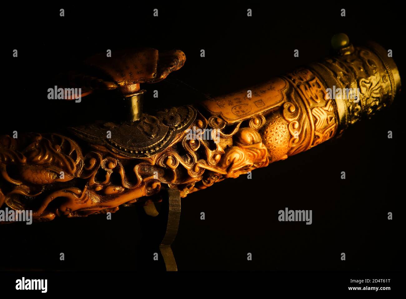 Closeup of illuminated isolated antique vietnamese opium smoking bone ...