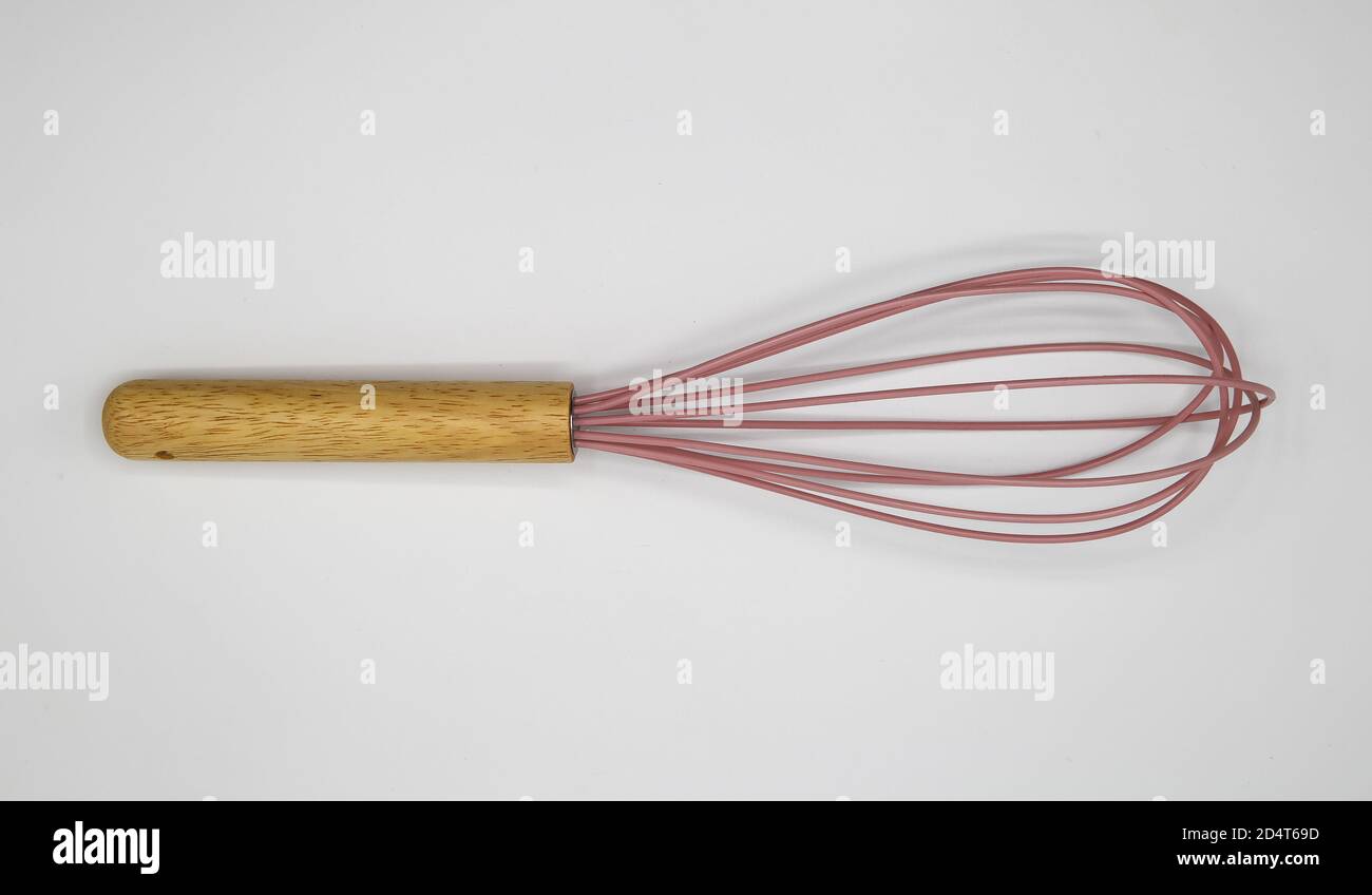Top down view on one isolated whisk with wood handle and pink wire ...