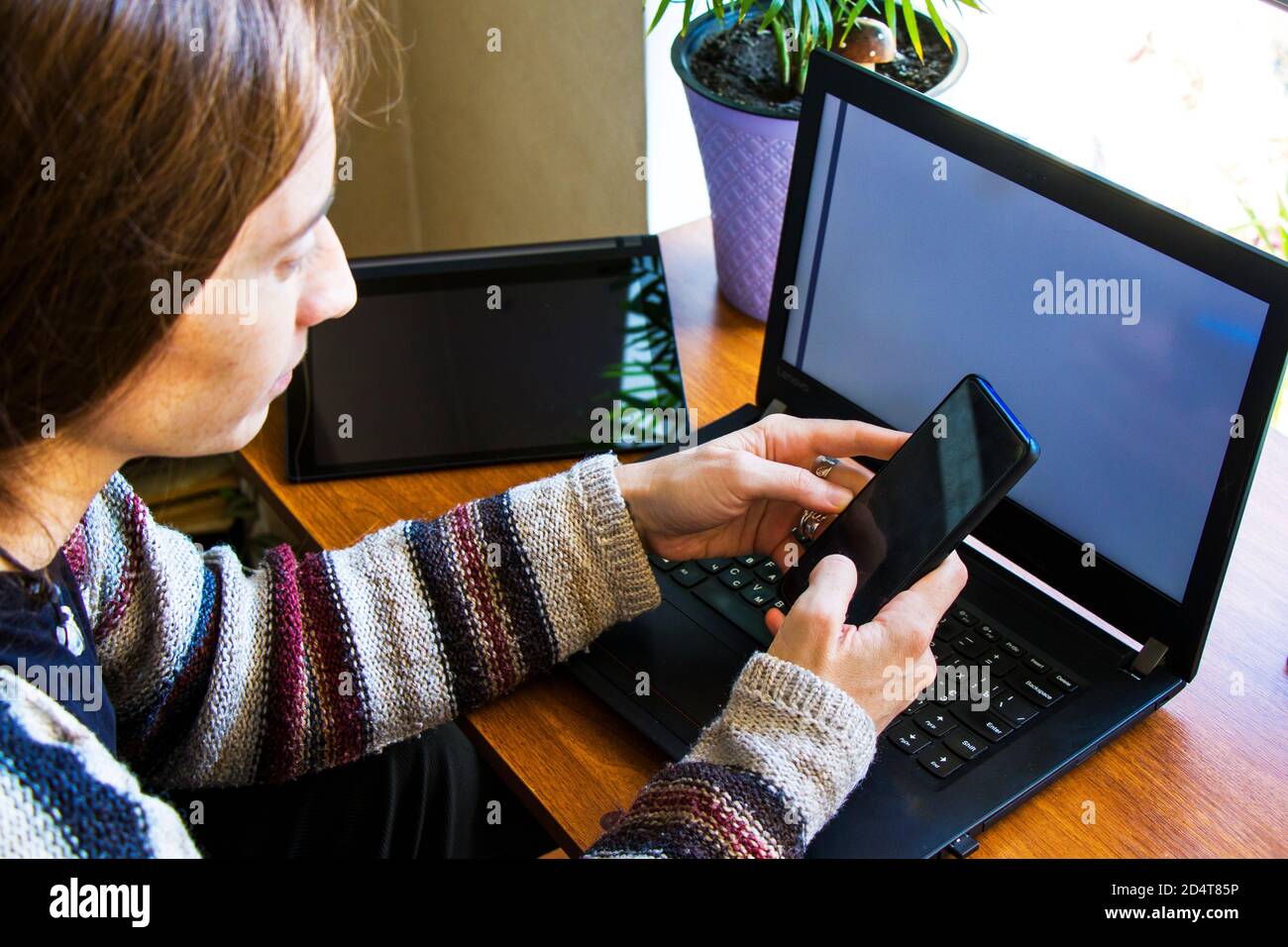 Woman working in office with digital tablet and notebook, writing and ...