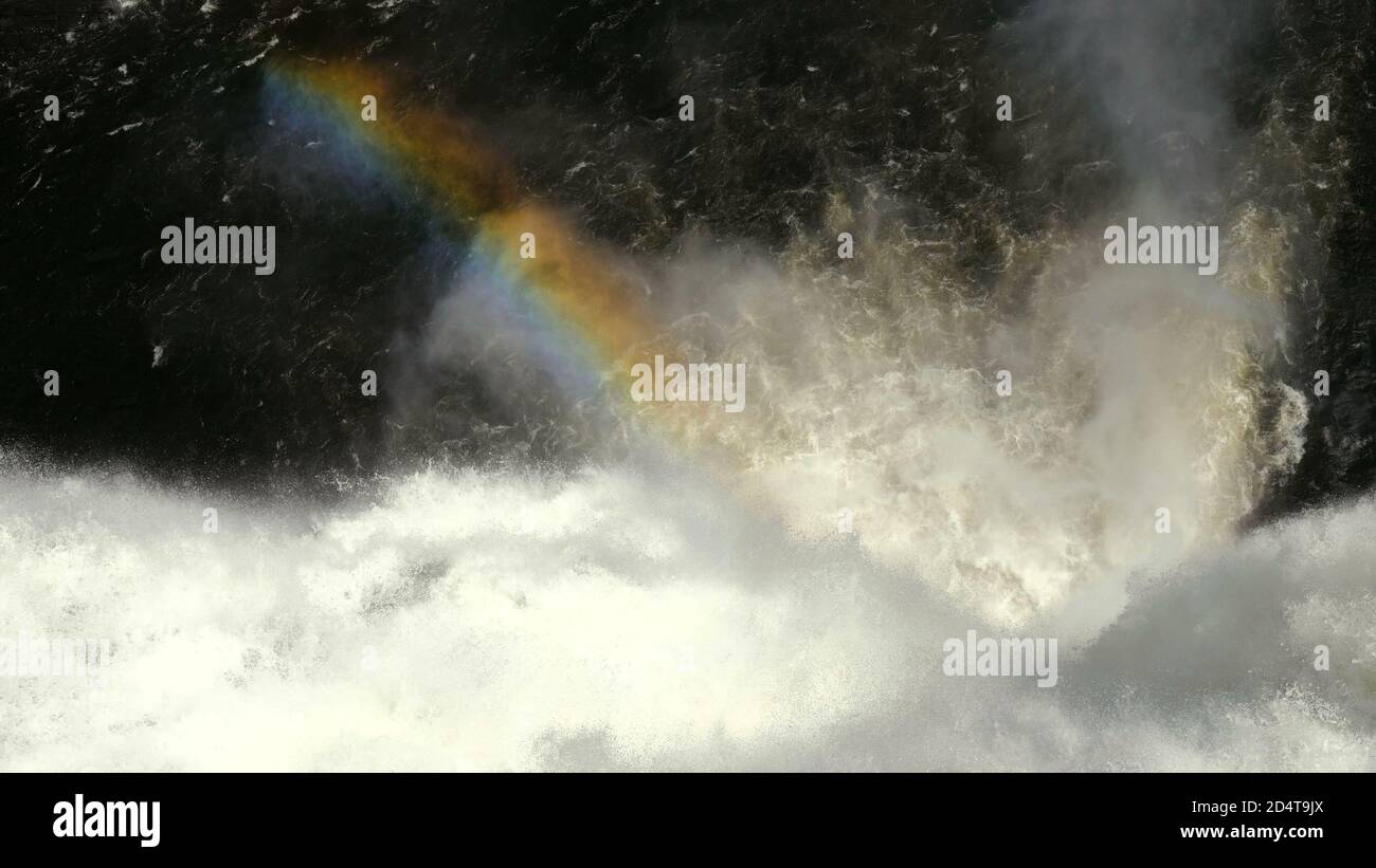 Rainbow over the running water of the waterfall Stock Photo - Alamy