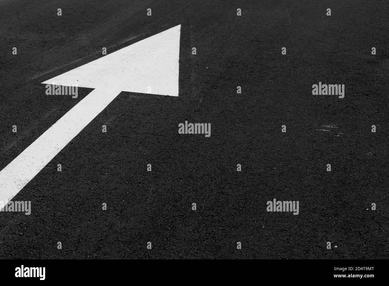 white arrow on asphalt to define direction Stock Photo - Alamy