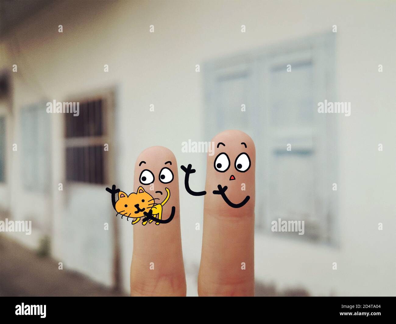 Two fingers are decorated as two person. They are at the back yard. One ...