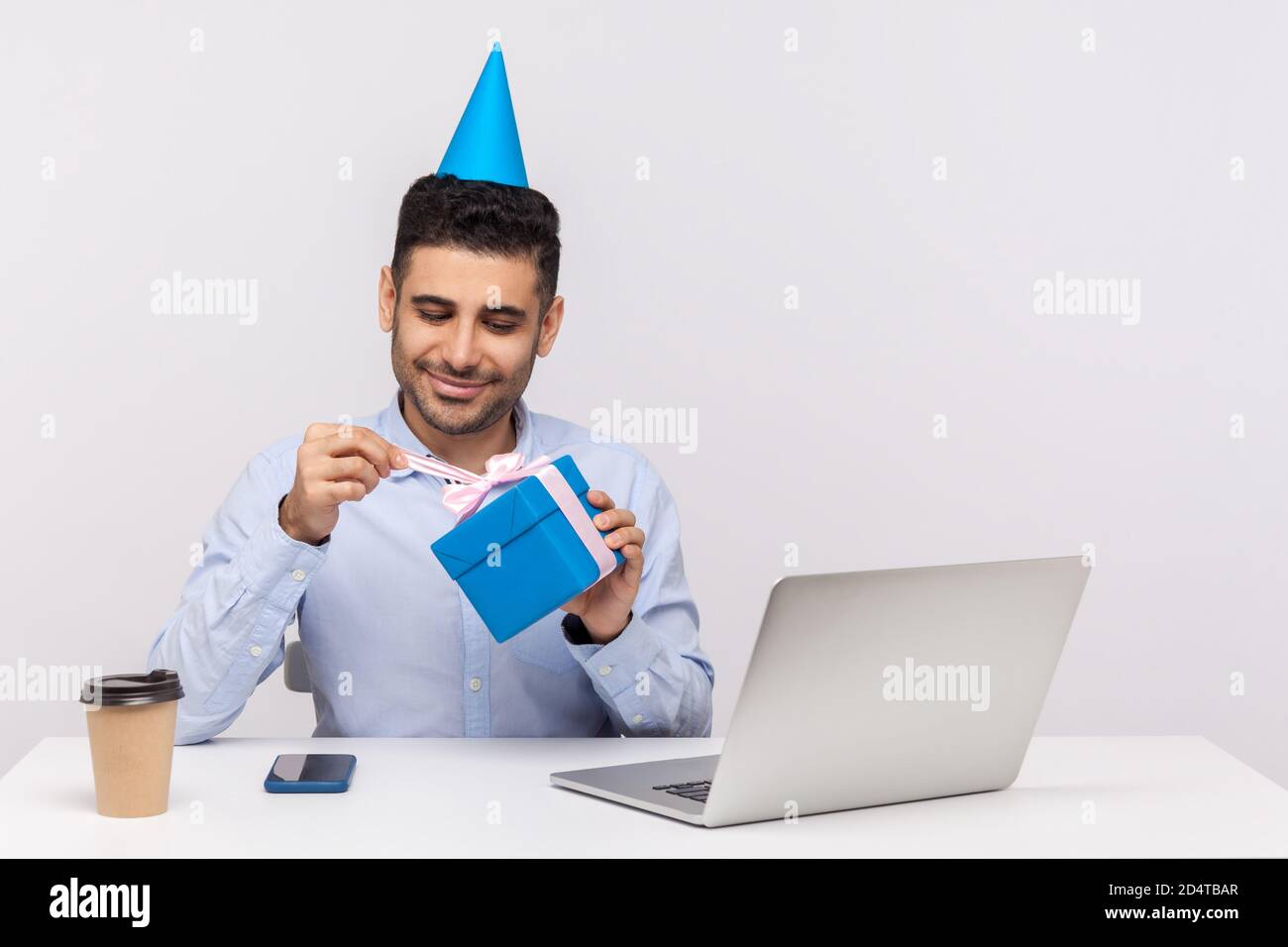 Happy employee guy with funny part cone sitting in office workplace ...