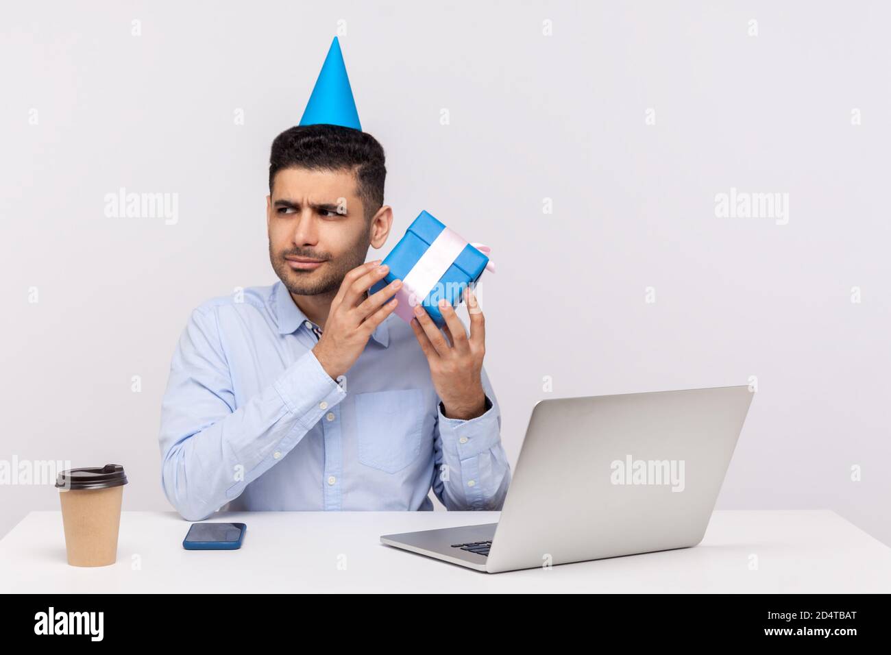 Employee guy with funny part cone sitting in office workplace ...